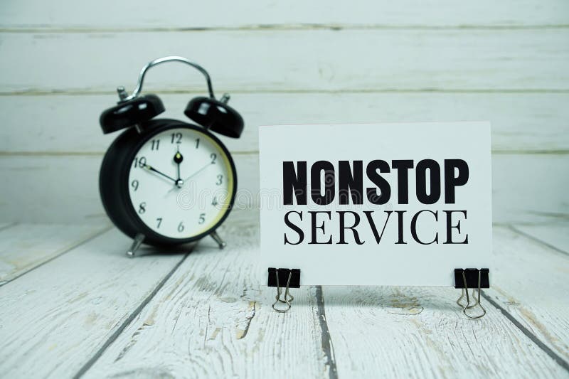 Nonstop Service Text Message on Paper Card with Alarm Clock on Wooden ...