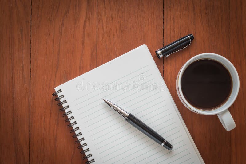 Note Book with Pen and a Cup of Coffee on Wood Table. Stock Image ...