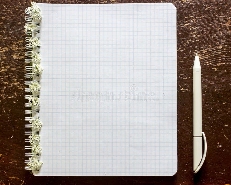 Notebook Adorned with Small White Flowers and Pen Lying on the O Stock ...