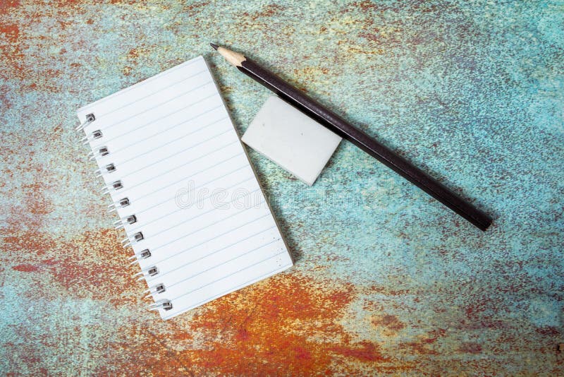 Notebook, Black Graphite Pencil and Eraser on a Rustic Metal Surface ...