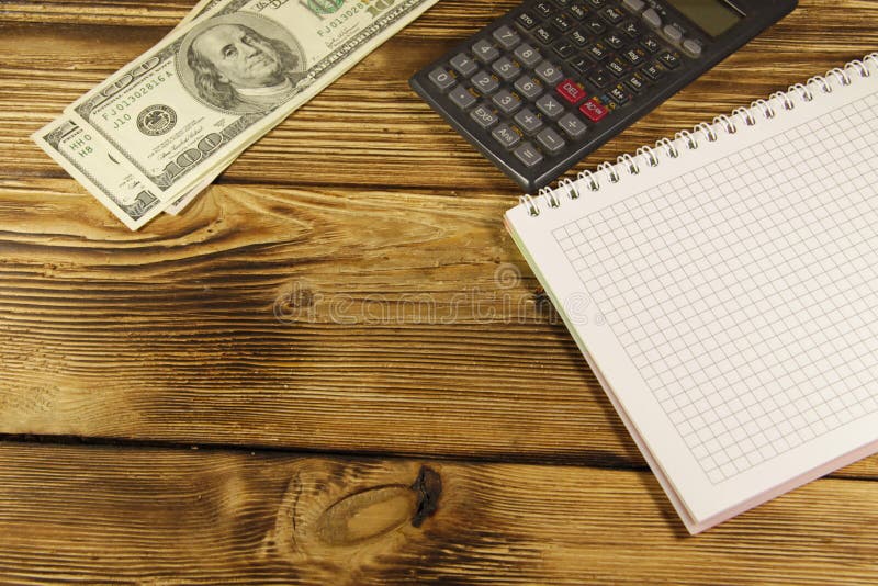 Notebook with Dollars and Calculator on Wooden Desk Stock Photo - Image ...