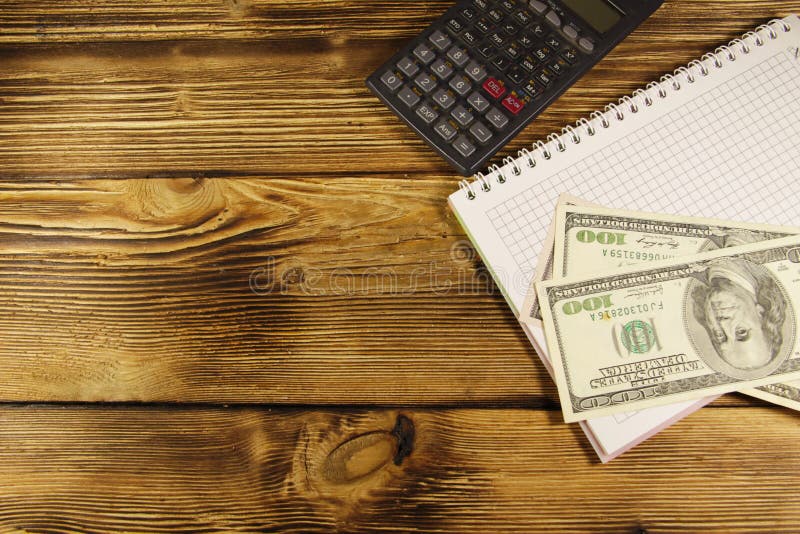 Notebook with Dollars and Calculator on Wooden Desk Stock Photo - Image ...