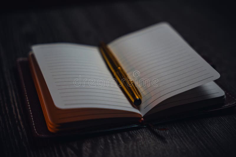 A Notebook with a Gold Pen on the Table in the Candlelight Stock Photo ...