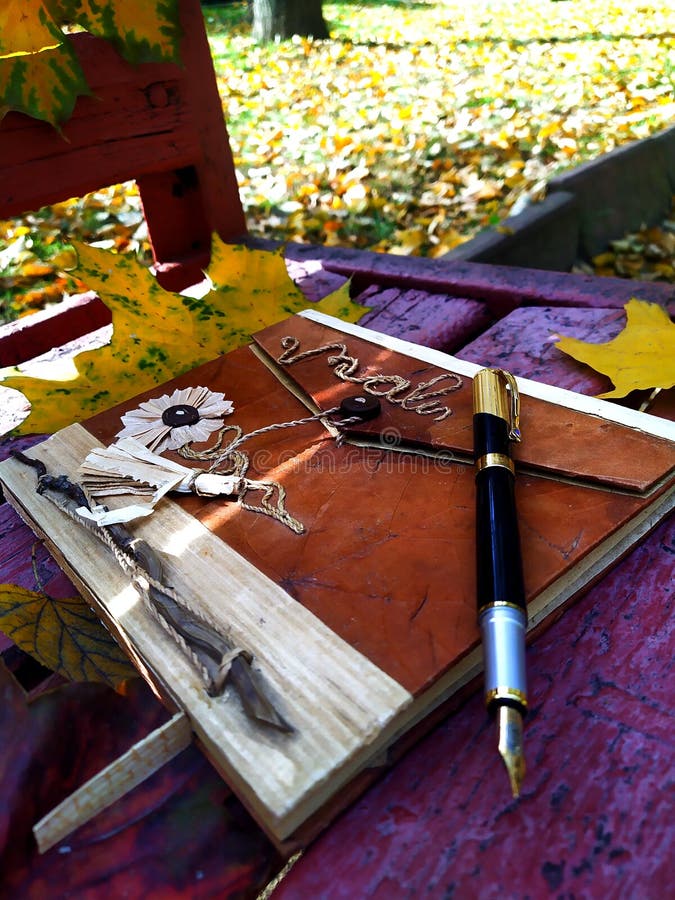 Notebook, Ink Pen on a Bench on the Background of Fallen Leaves in the ...