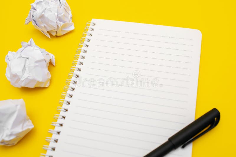 Notebook and Pen with Crumpled Sheets on a Yellow Background Stock ...