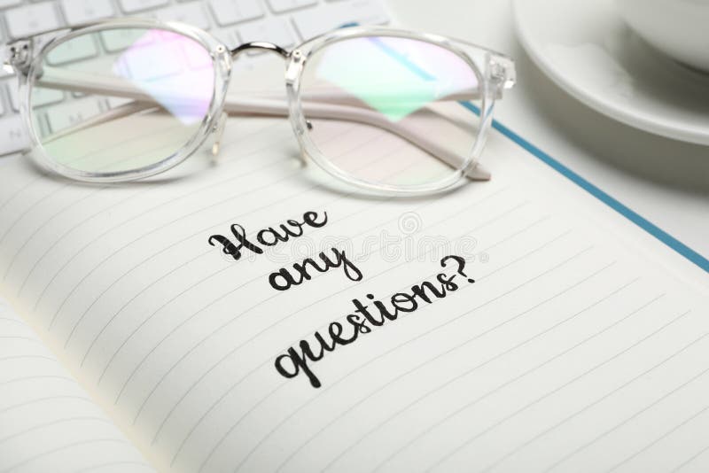 Notebook with Phrase HAVE ANY QUESTIONS and Eyeglasses on Table Stock ...