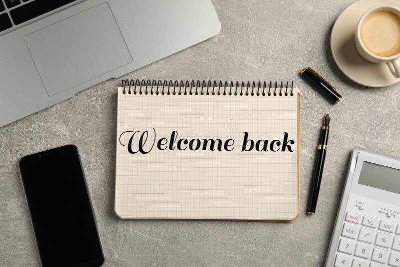 Notebook with Phrase Welcome Back on Grey Table. Office Desk with ...
