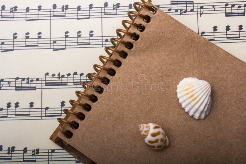 Notebook Placed on Paper with Musical Notes Stock Image - Image of ...