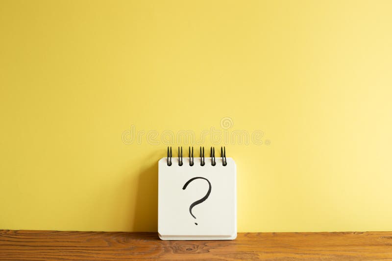 Notebook with Question Mark on Wooden Desk. Yellow Wall Background ...