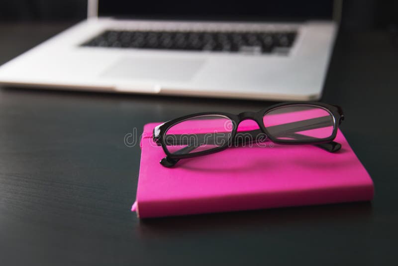 Notebook, Reading Glasses and Laptop Computer on Black Desk Stock Photo ...