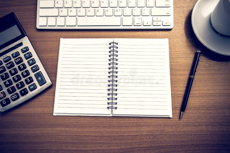 Notebook is on the Table with Calculator and Coffee and Computer ...