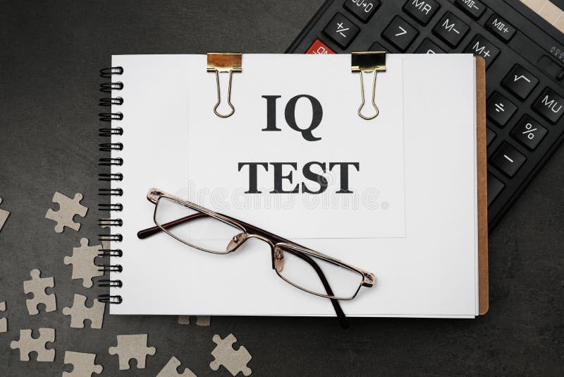 Notebook with Words IQ Test, Calculator and Puzzles on Black Table ...