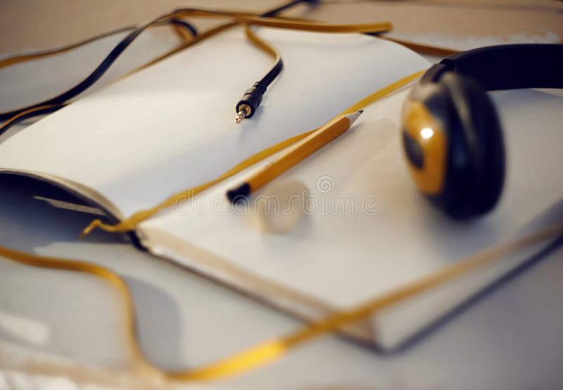 Notebook with Yellow Bookmark, Pencil and Headphones Stock Photo ...