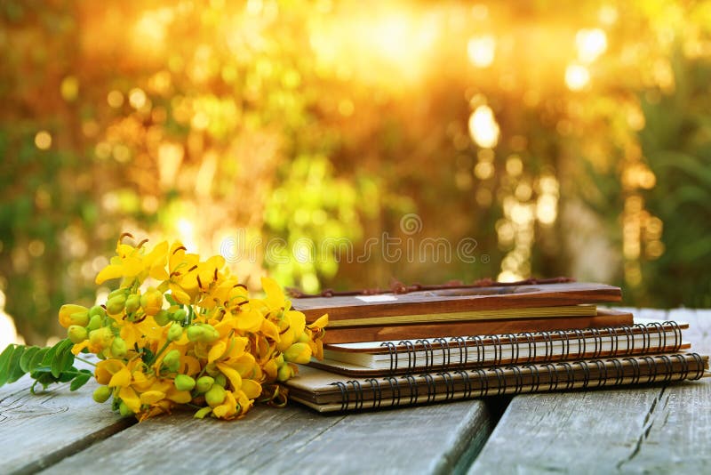 Notebooks Next To Field Flowers on Wooden Table Outdoors Stock Photo ...