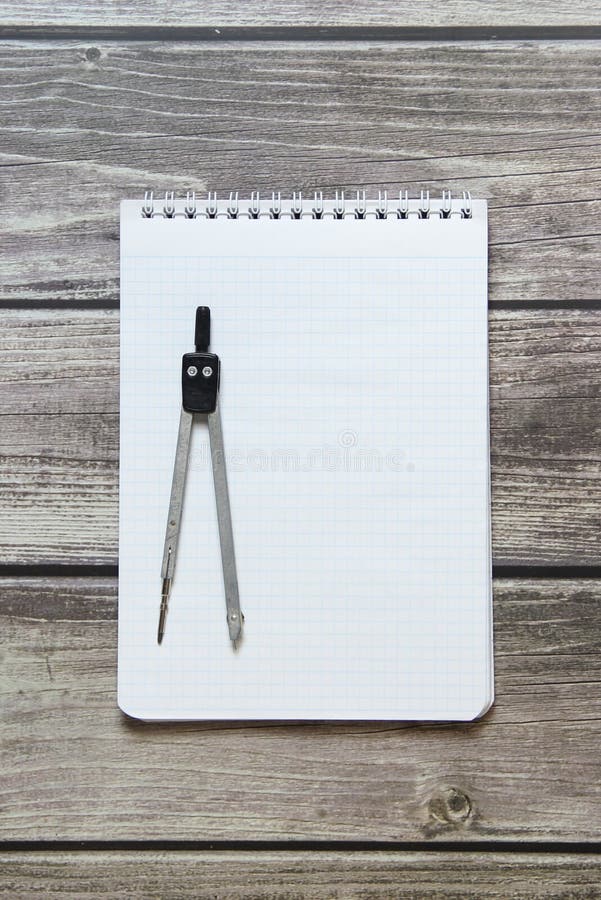 Notepad with a Blank White Sheet in a Checker Paper with Compass Lies ...