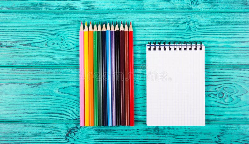 Notepad and Colored Pencils on a Blue Background. Stationery on the ...