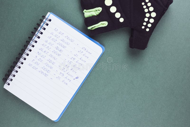 A Notepad with Dates and Distance Cycled on Natural Green Background ...