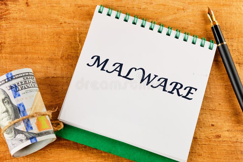 A Notepad Displays the Word Malware, Highlighting a Significant Cybersecurity Issue. a Rolled ...