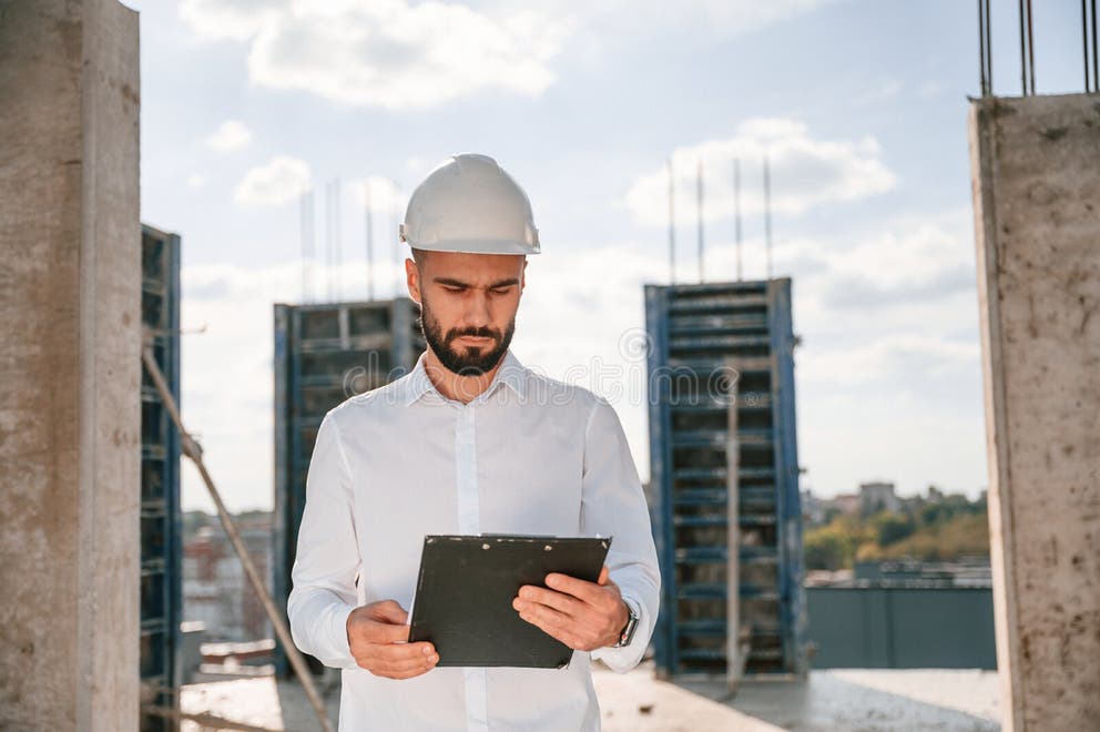 With Notepad with Documents. Foreman in Uniform is Working on the ...