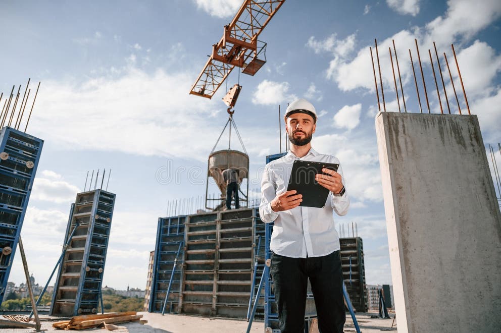 With Notepad with Documents. Foreman in Uniform is Working on the ...