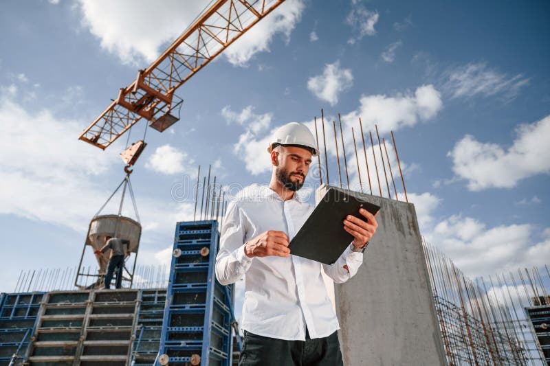 With Notepad with Documents. Foreman in Uniform is Working on the ...
