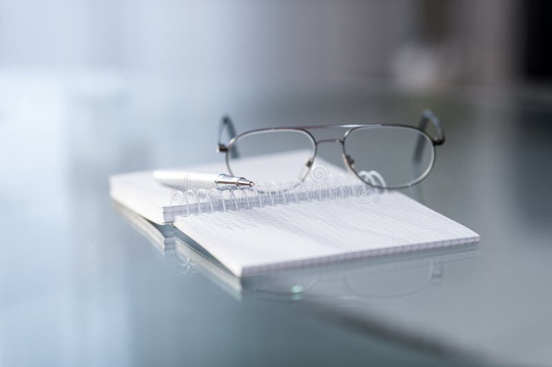 Notepad on glass table stock image. Image of glasses - 23571085