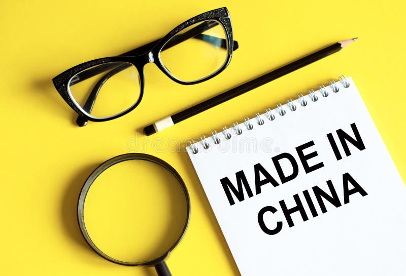 Notepad with MADE in CHINA Note on Yellow Desk with Glasses, Pencil and ...