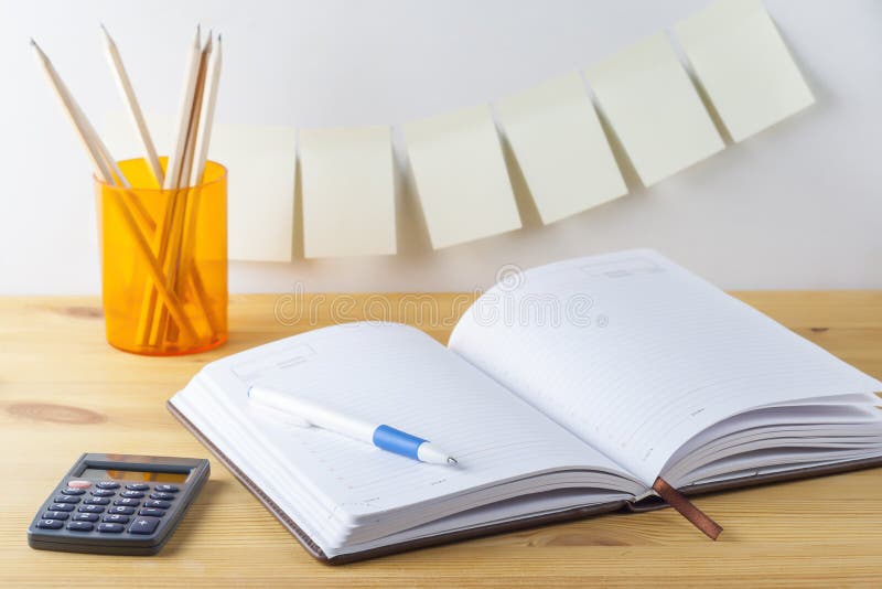 Notepad with Pen Container with Pencils, Calculator are on a Wooden ...