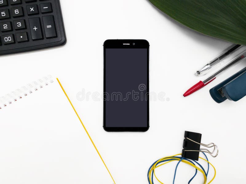 A Notepad and a Phone with a Blank Screen on a White Table Around ...