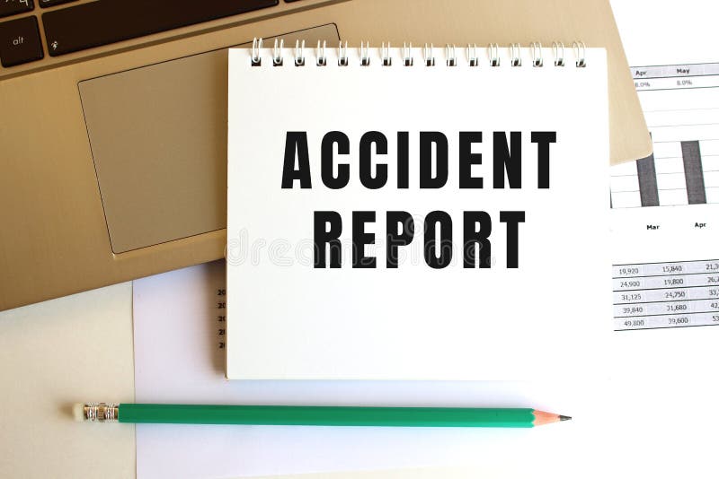 Notepad with the Text ACCIDENT REPORT is on the Laptop Keyboard ...