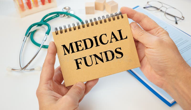 Notepad with Text MEDICAL FUNDS in the Hands of a Doctor and a ...
