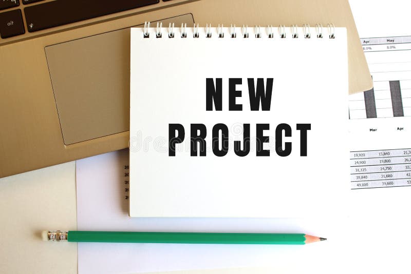 Notepad with the Text NEW PROJECT is on the Laptop Keyboard. Business ...