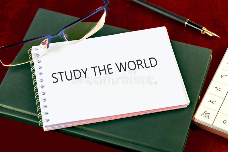 A Notepad with the Words Study the World Sits on a Green Book, Accompanied by Glasses and a Pen ...