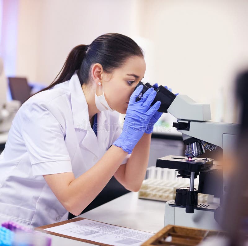 Nothing Escapes Her Eye. a Young Scientist Using a Microscope in a ...