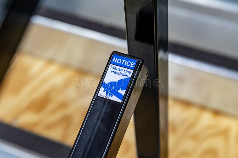 A Notice Sticker `Please Use Handrails` on a Black Handrails Stock ...