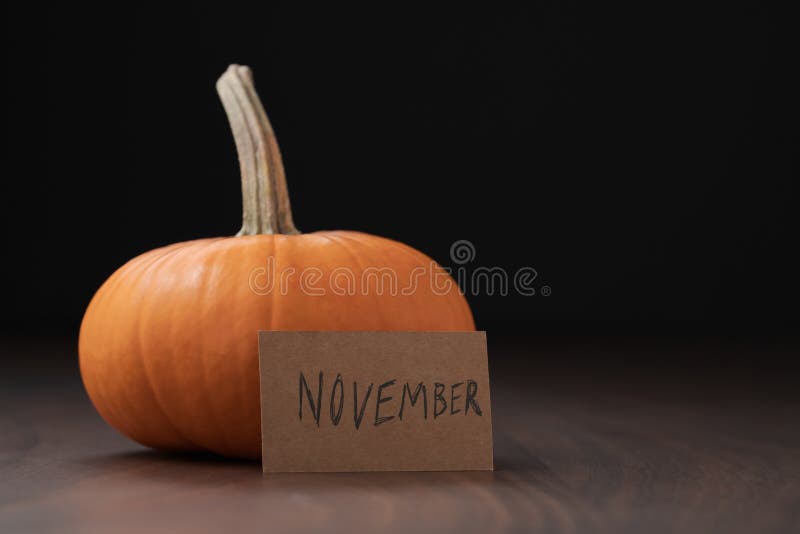 November Card Next To Small Orange Pumpkin on Walnut Table Stock Photo ...