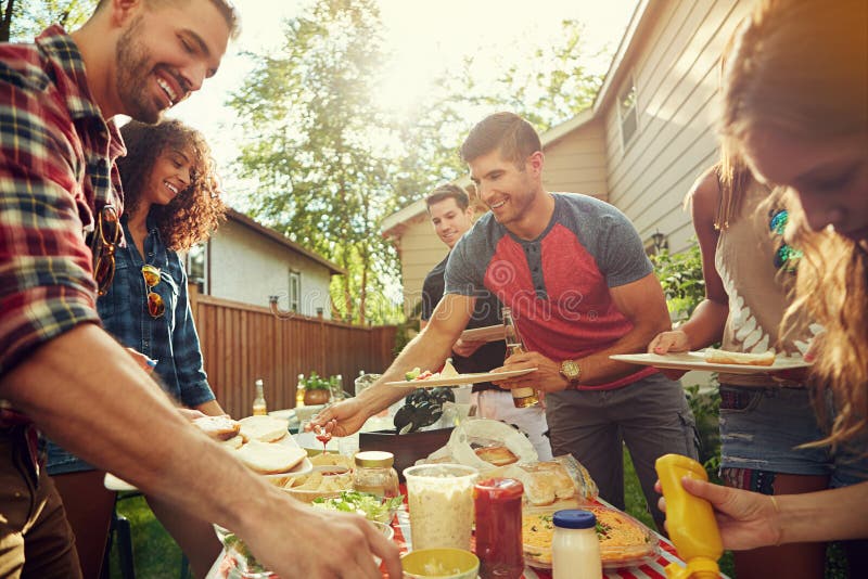 Now we Eat. a Group of Friends Having Lunch in Their Backyard. Stock ...