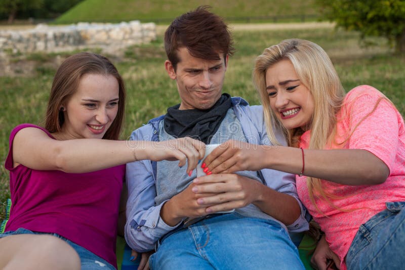 Now My Turn! Three Friends Fighting for a Mobile Phone. Stock Photo ...