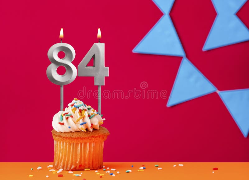 Number 84 Candle with Birthday Cupcake on a Red Background with Blue ...