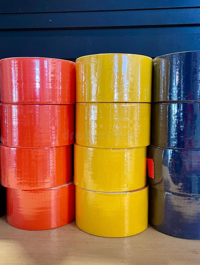 A Number of Different Colored Packaging Tape on a Shelf Above a Black ...