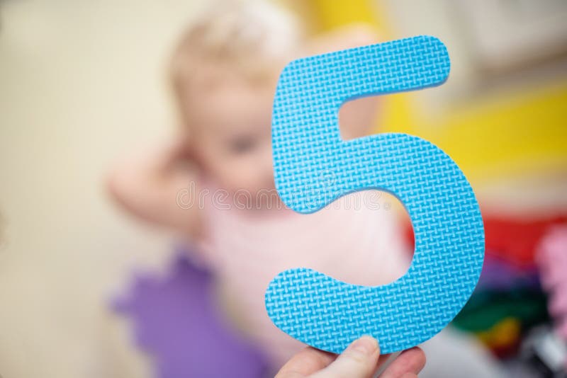 Number 5 Five on Background of Blurred Child. Small Child Plays on the ...