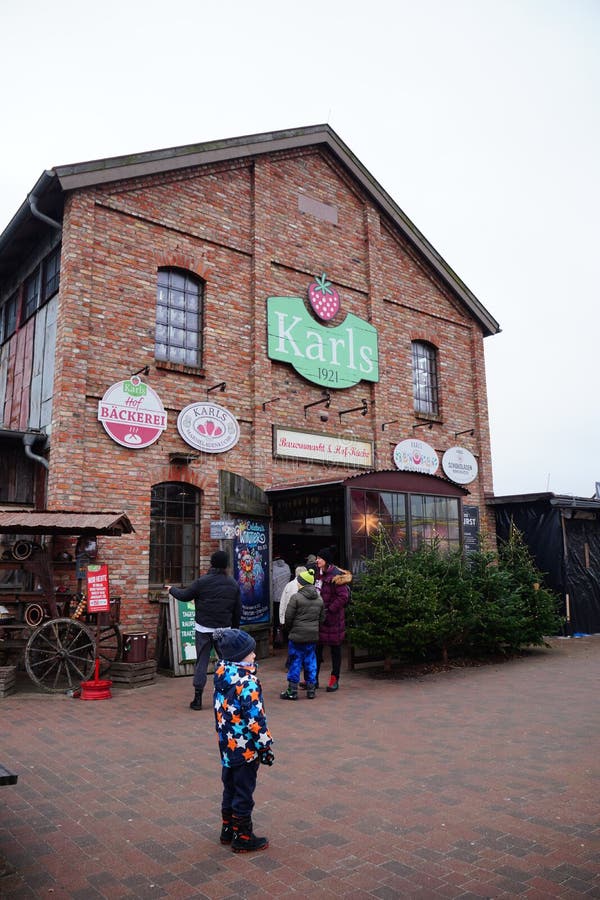 Number of People Standing in Front of a Red Brick Storefront in Germany ...