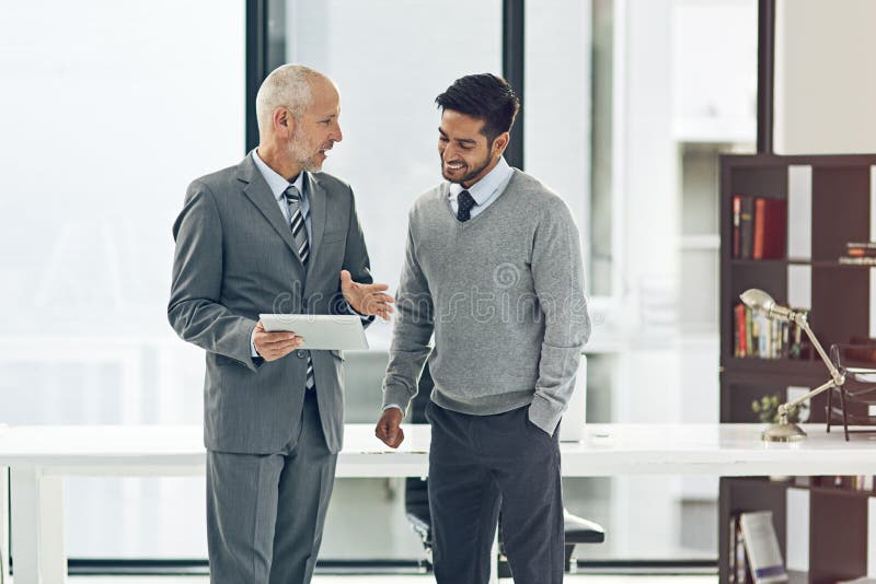 These Numbers Look Good. Two Businessmen Looking at a Digital Tablet in ...