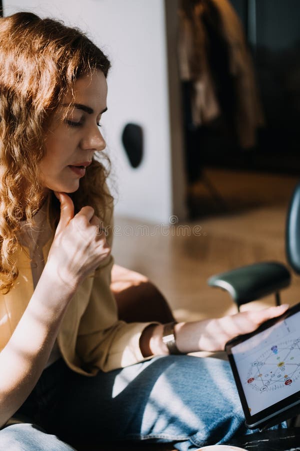 Numerologist Analyzing a Personal Numerology Chart on a Tablet in a ...