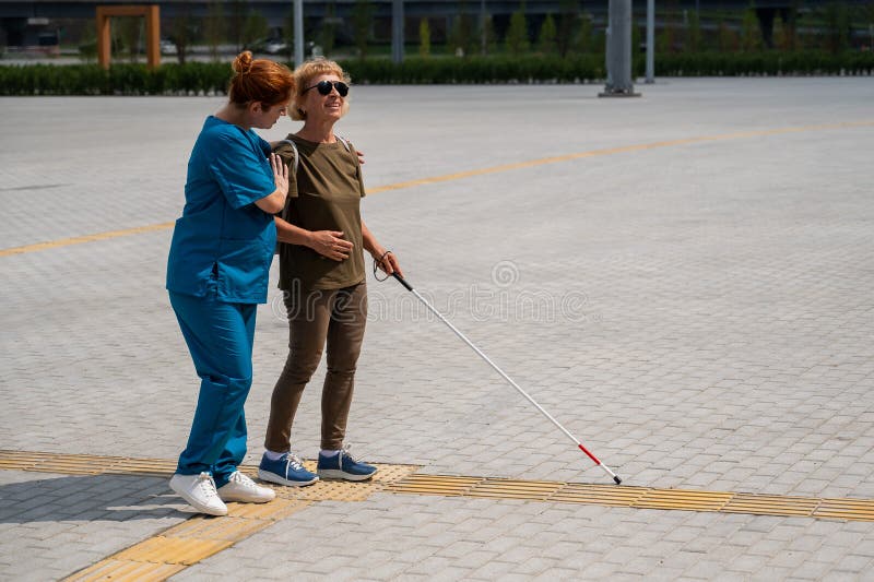 A Nurse Accompanies an Elderly Blind Woman on a Walk. Stock Image ...
