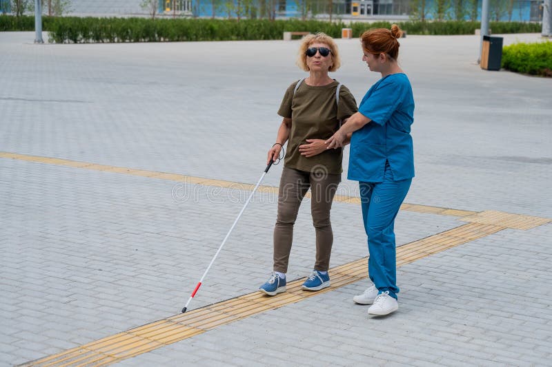 A Nurse Accompanies an Elderly Blind Woman on a Walk. Stock Image ...
