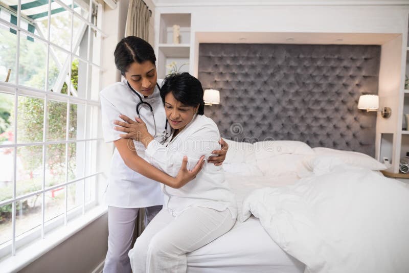 Nurse Assisting Patient on Bed at Home Stock Photo - Image of equipment ...