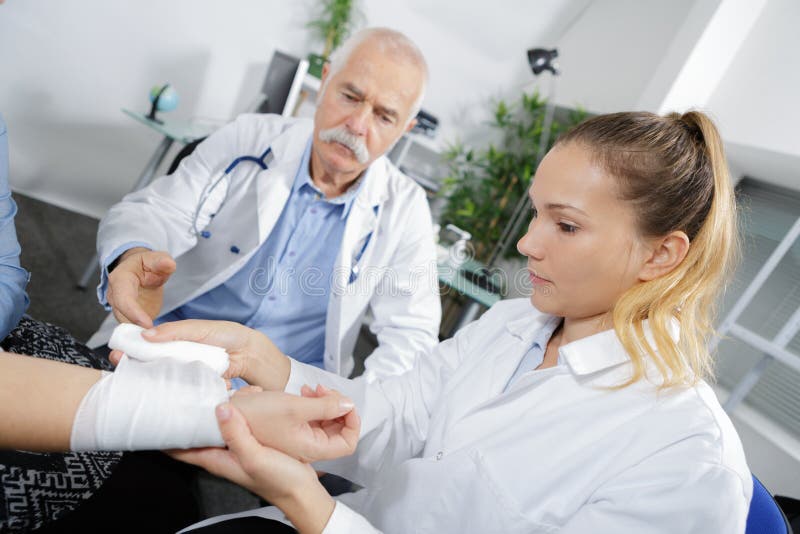 Nurse Being Supervised To Bandage Patients Wrist Stock Image - Image of ...