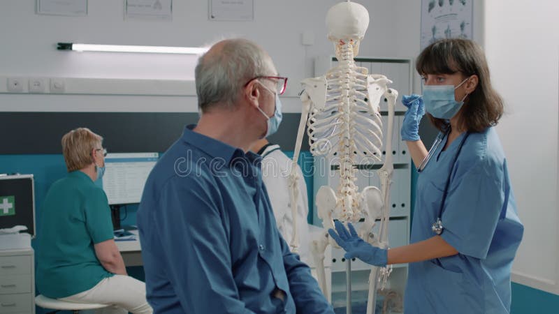 Nurse with Face Mask Explaining Bones on Human Skeleton Stock Footage ...