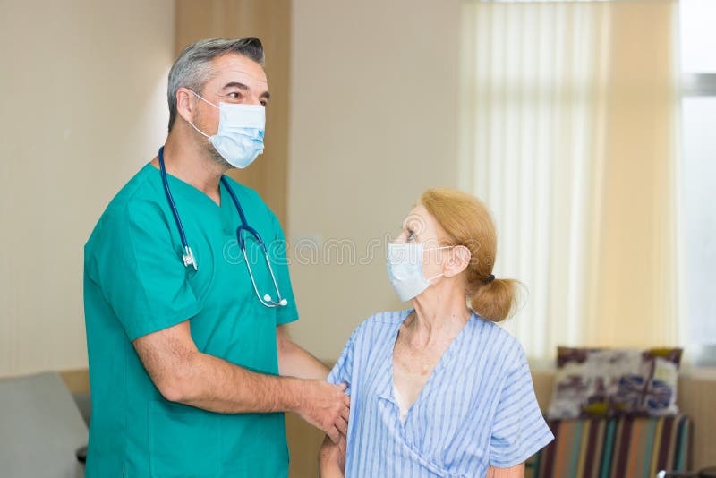 A Nurse is Guarding an Elderly Patient while Both are Wearing a ...